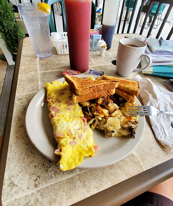 The Western omelet and home fries combo&mdash;where breakfast dreams come true. That perfect fold hiding savory treasures inside would make any French chef nod in approval.