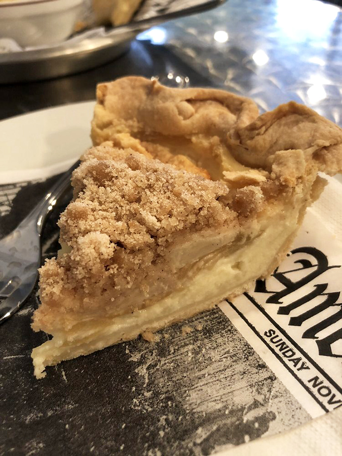 Apple pie with a crumb topping that would make Grandma both proud and suspiciously competitive. The newspaper underneath might contain less juicy stories.