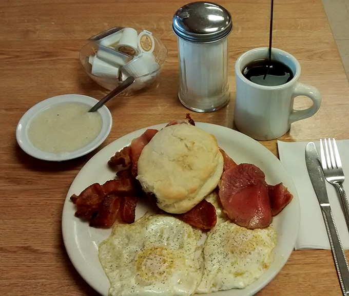 Breakfast of champions: eggs with perfect sunny centers, bacon with the ideal crisp-to-chew ratio, and a biscuit that deserves its own fan club.
