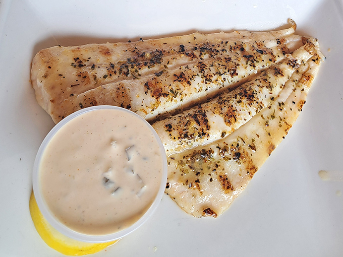 Blackened fish that's seen just enough heat to develop character. That creamy sauce alongside? Your taste buds' new best friend.