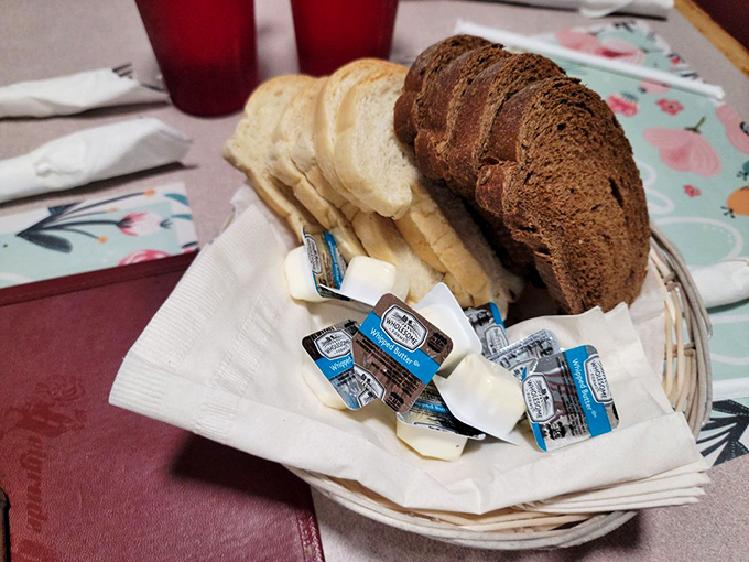 Bread basket diplomacy: white, wheat, and pumpernickel living in perfect harmony with butter packets standing guard.