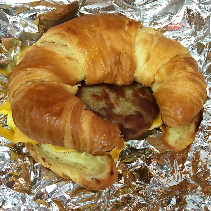 Breakfast engineering at its finest &ndash; a golden croissant embracing eggs, cheese and meat in a portable morning masterpiece.