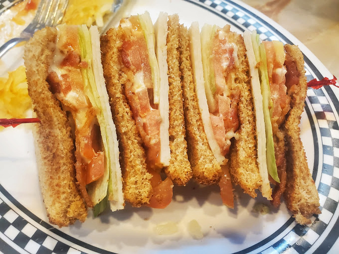 This isn't just a club sandwich; it's architecture with mayo. Perfectly stacked, precisely cut, ready for its Instagram moment.