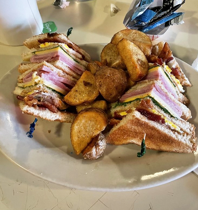 This isn't just a club sandwich&mdash;it's architecture. Layers of ham, bacon, and cheese create the skyscraper of sandwiches, with crispy potatoes standing guard.