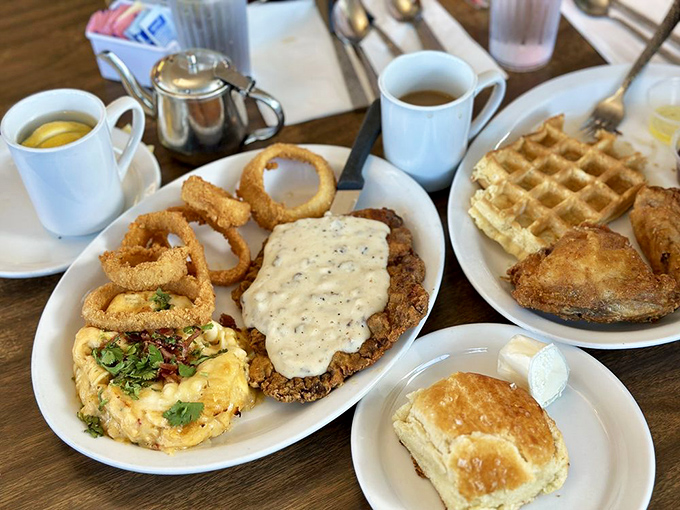 Comfort food trifecta: crispy onion rings, country-fried steak smothered in gravy, and a biscuit that could float away if not weighed down with butter.