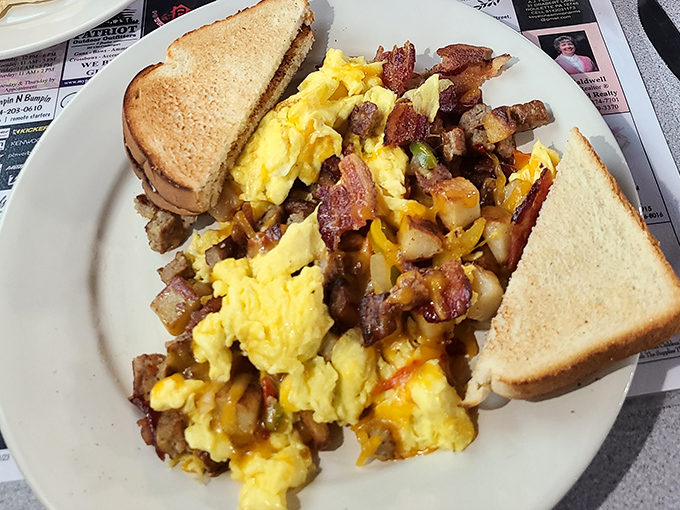 Breakfast alchemy: scrambled eggs mingling with potatoes and bacon bits, creating a plate that says "good morning" better than words ever could.