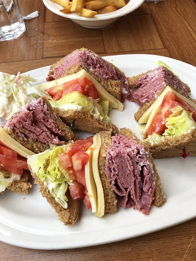 Architecture meets artistry in this towering corned beef masterpiece. Each triangular section contains the perfect meat-to-cheese-to-vegetable ratio that sandwich scientists have sought for generations. 