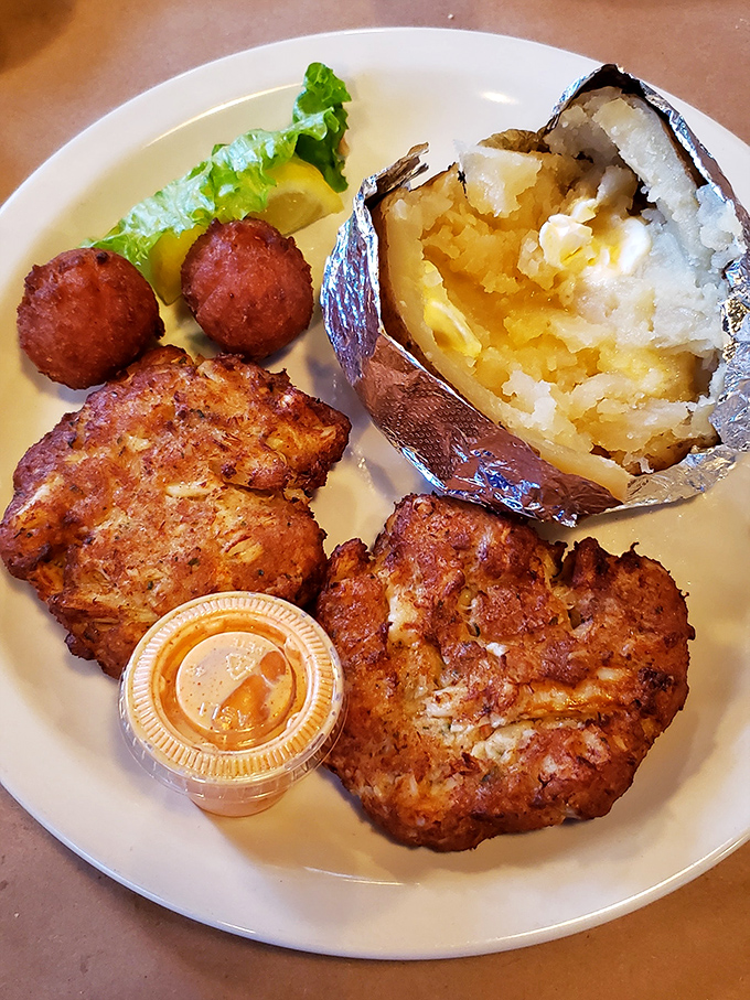 Golden-brown crab cakes that are actually crab (imagine that!), served alongside hushpuppies and a baked potato that's dressed for the occasion.