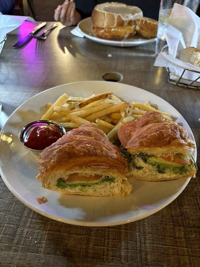 A sandwich that would make Neptune himself jealous&mdash;flaky croissant embracing fresh seafood with fries standing at attention.