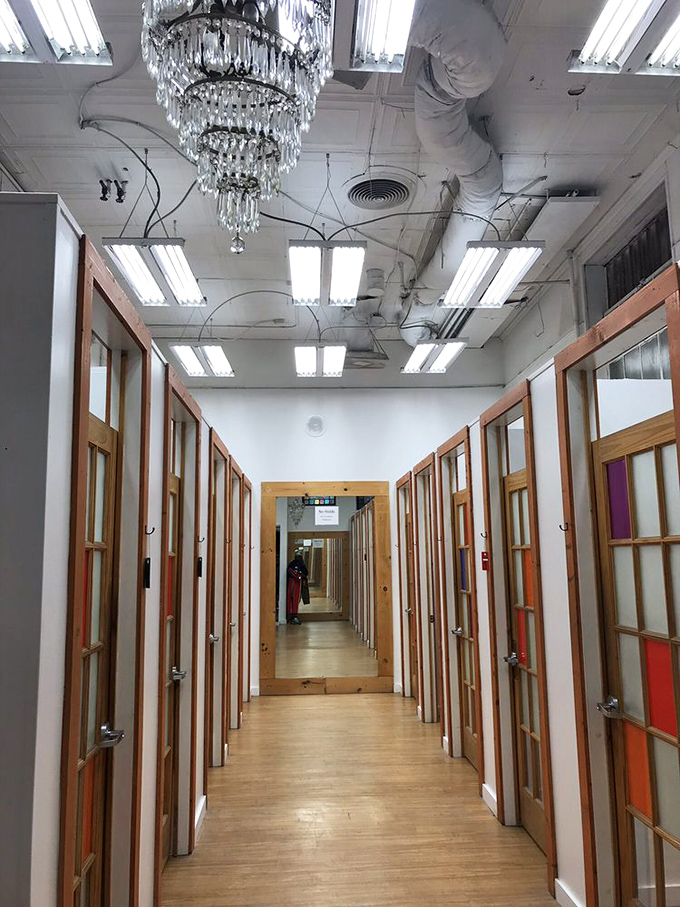 A crystal chandelier adds unexpected elegance to the dressing room corridor, where fashion dreams are confirmed or gently redirected.
