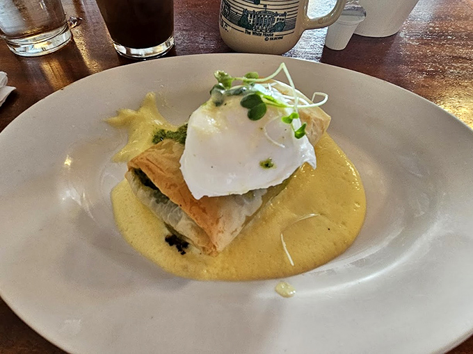 Eggs Benedict elevated to art form, where hollandaise sauce flows like liquid sunshine over perfectly poached perfection.