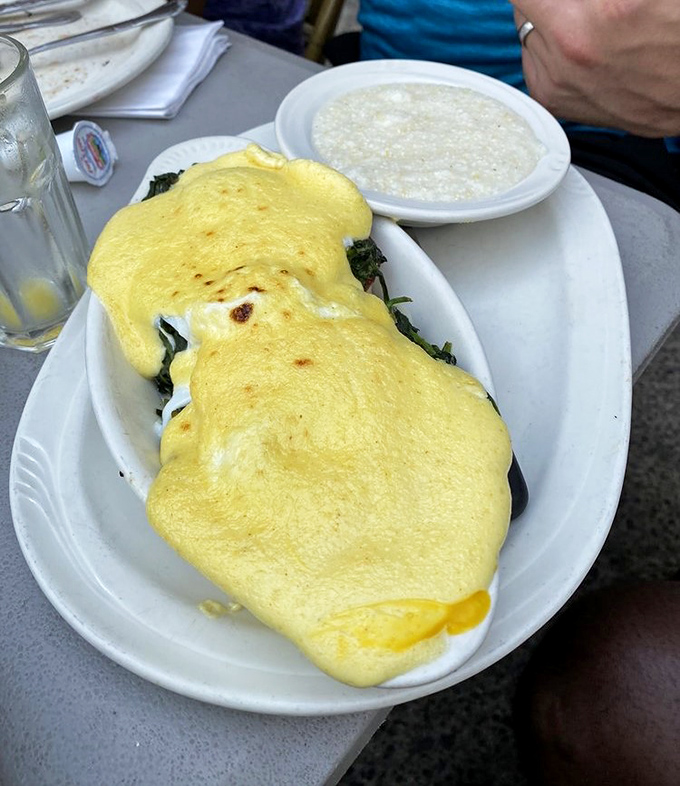 Eggs Benedict that would make a French chef weep with joy. That hollandaise blanket looks like sunshine itself decided to take a nap on your breakfast.