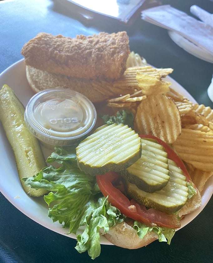 The sandwich that launched a thousand napkins—crispy, golden-brown perfection nestled between fresh veggies and a bun that knows its supporting role.