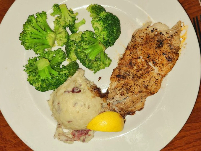 A perfectly grilled fish fillet that proves simplicity is the ultimate sophistication, especially when paired with fresh broccoli and homestyle potatoes.