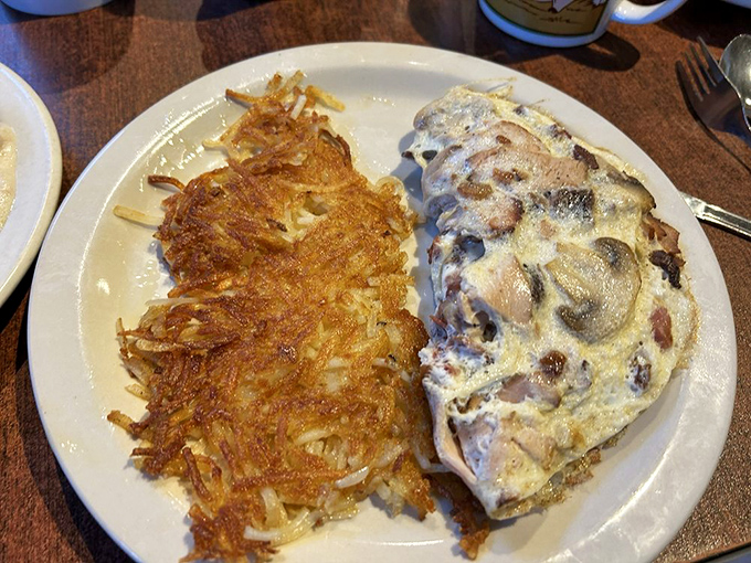 Crispy hashbrowns that crackle with each bite alongside an omelet that's practically strutting with confidence. Morning glory on a plate.