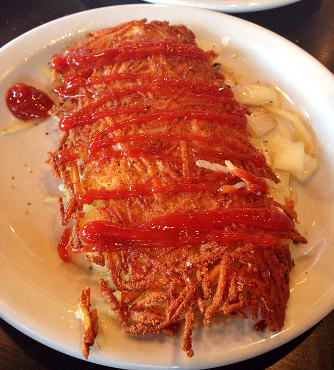 Hash brown architecture at its finest&mdash;crispy exterior, tender interior, with ketchup racing stripes for that touch of Midwestern elegance.