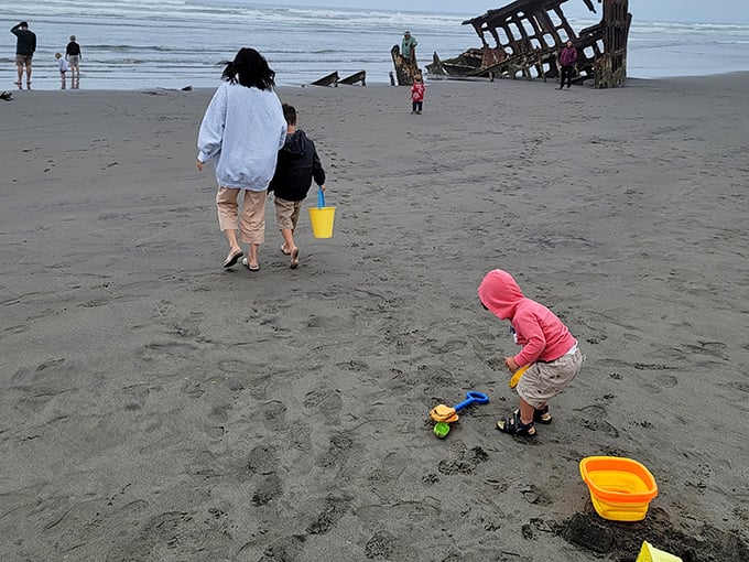 Building sandcastles in the shadow of a shipwreck&mdash;childhood wonder meets historical tragedy in this perfect Oregon beach day scenario.