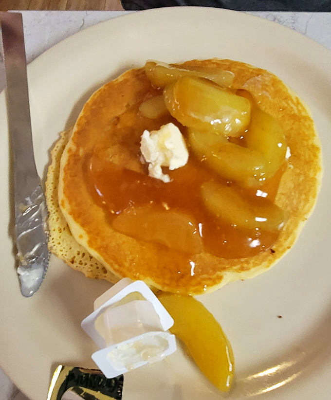 Fluffy pancakes crowned with butter and syrup, proving breakfast perfection never goes out of style.