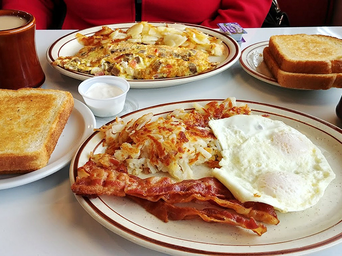 Breakfast perfection on a plate&mdash;crispy bacon, eggs with sunshine-yellow yolks, and hash browns that crackle with each forkful.