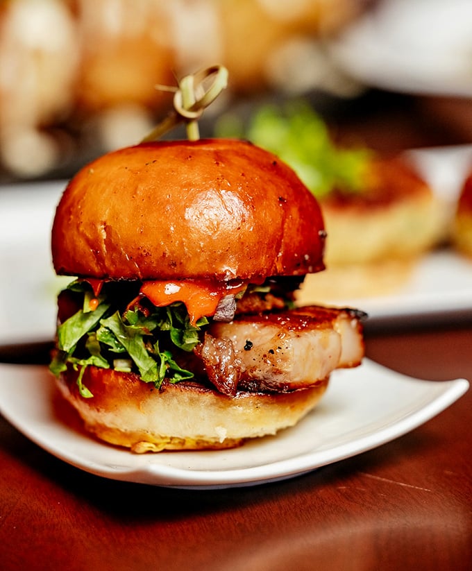 This isn't just a slider—it's a tiny architectural marvel of pork, greens, and glossy brioche that demands to be admired before it disappears.