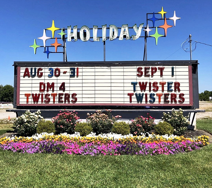 The Holiday marquee blooms amid a garden of flowers, announcing tonight's feature with mid-century flair.