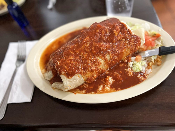This smothered burrito isn't hiding under that sauce &ndash; it's basking in it, like a tortilla-wrapped treasure bathing in a pool of culinary glory.
