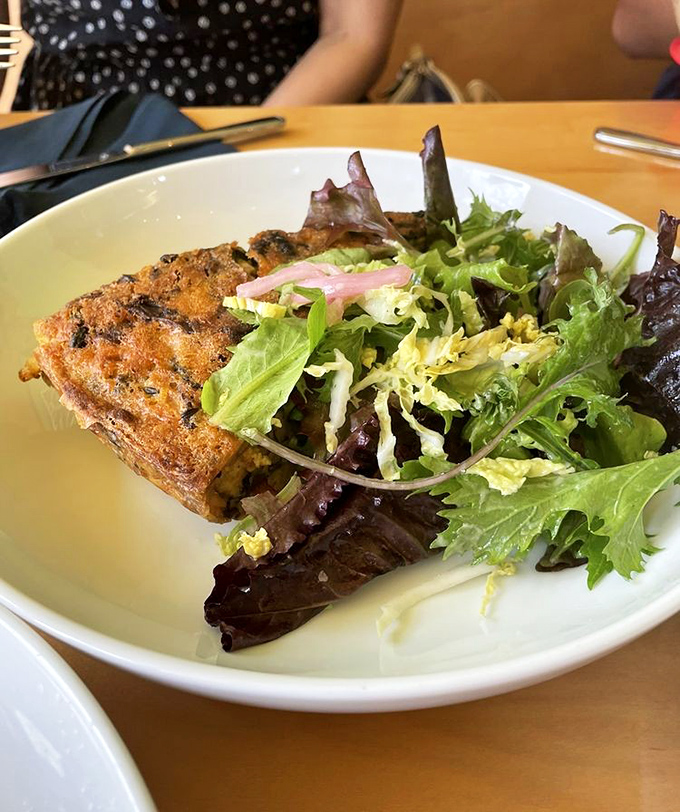 A slice of savory frittata paired with fresh greens creates that rare breakfast that feels both virtuous and indulgent.