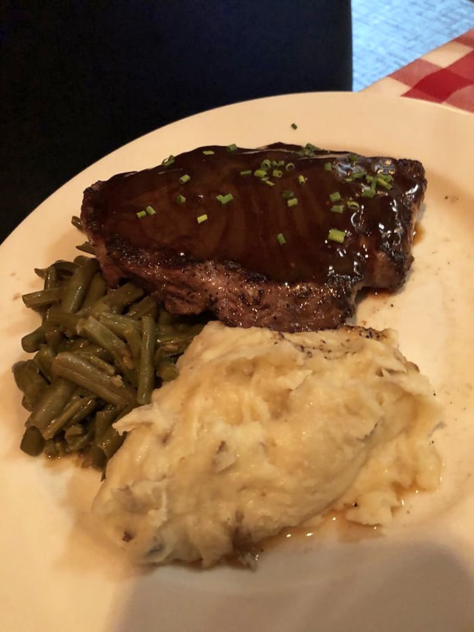 This isn't just a steak; it's a masterclass in simplicity &ndash; perfectly seared, resting on green beans with a side of mashed potatoes that look cloud-soft.