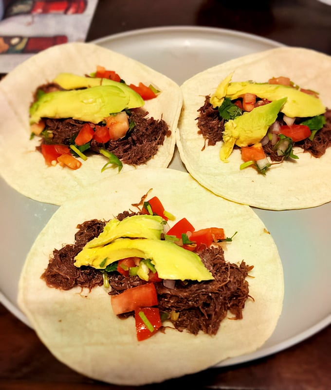 Beautifully plated barbacoa tacos showcase the rich, dark meat that makes this humble spot a local legend.