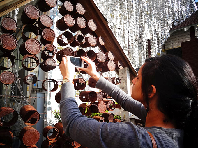 Visitors can't resist capturing the intricate details. Each can represents not just a beverage consumed, but a piece of American advertising history.