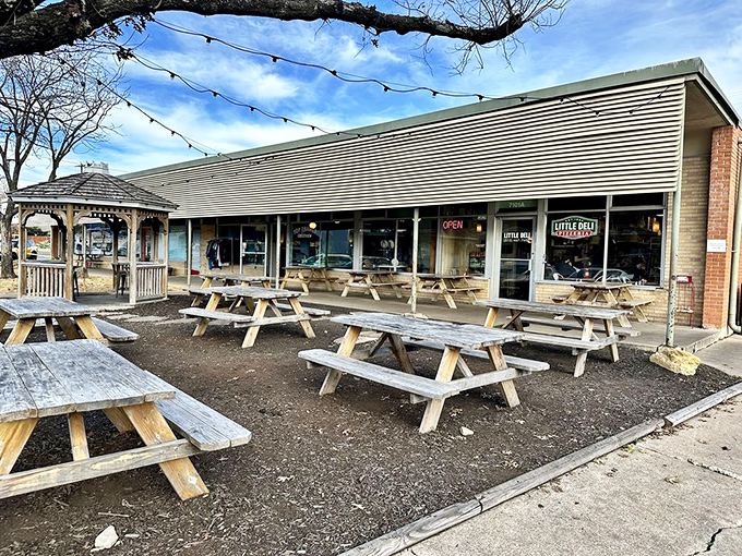 Picnic tables waiting for hungry visitors under string lights&mdash;Little Deli's outdoor space is pure Austin charm on a plate. 