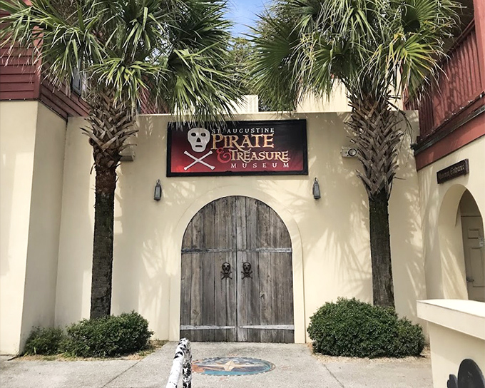 Heavy wooden doors flanked by palm trees – the perfect entrance for a treasure trove of pirate lore.