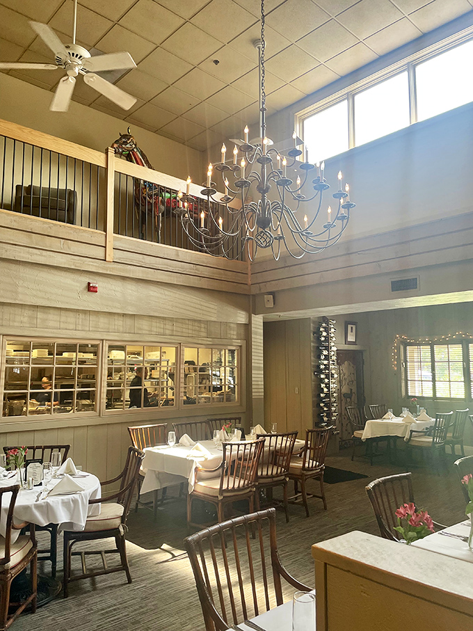 Chandelier light dancing across white tablecloths. The Back Burner's dining room says "yes, your steak deserves this setting."