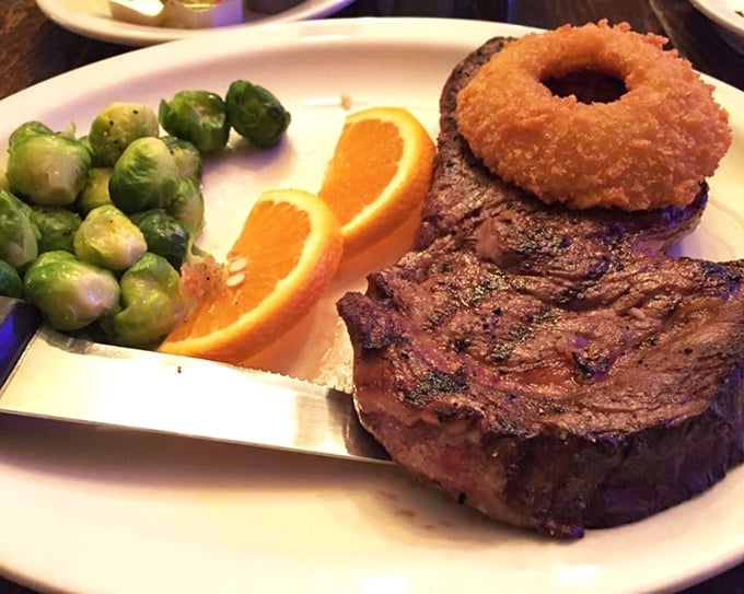A perfectly seared steak with brussels sprouts and an onion ring—proof that sometimes the simplest combinations create the most profound happiness.