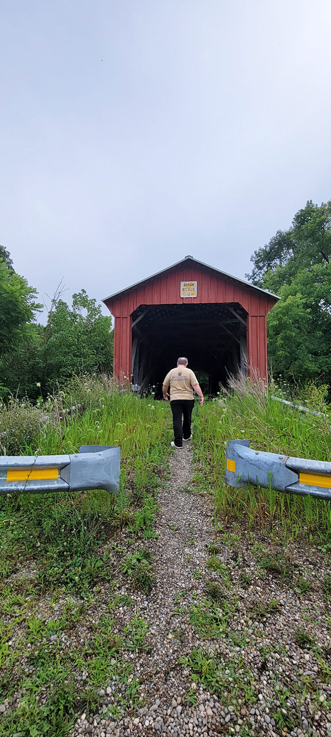 The approach to Shinn Bridge feels like walking into a storybook, complete with overgrown pathway and the promise of adventure ahead.