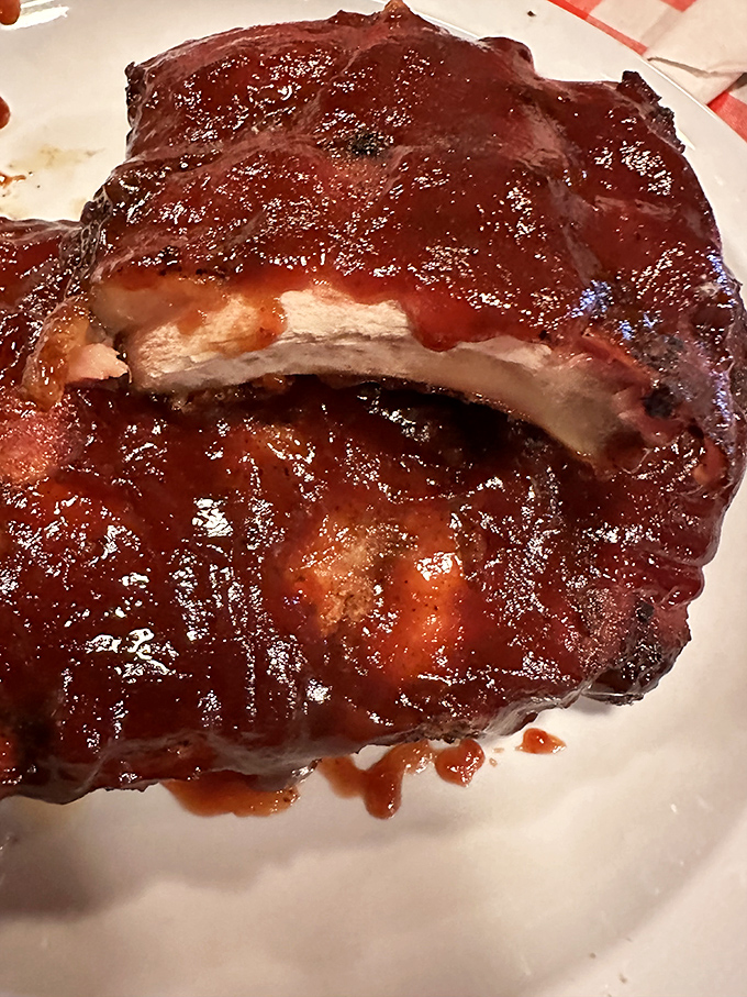 These ribs wear their sauce like a glossy coat of armor. The meat's not falling off the bone &ndash; it's making a graceful, dignified exit.