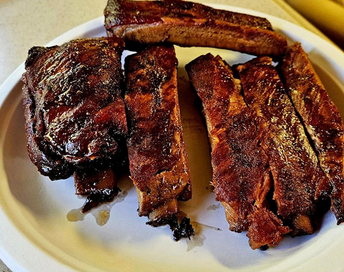 These ribs have the kind of bark that makes tree bark jealous, with a smoke ring so perfect it could be framed in a museum.