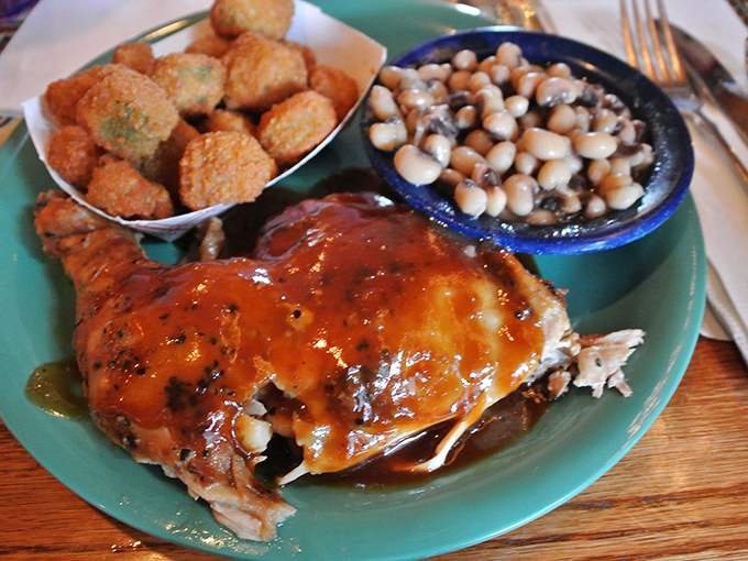 BBQ chicken wearing its sauce like a badge of honor, with black-eyed peas and corn fritters standing proudly alongside &ndash; a plate of Southern dignity. 