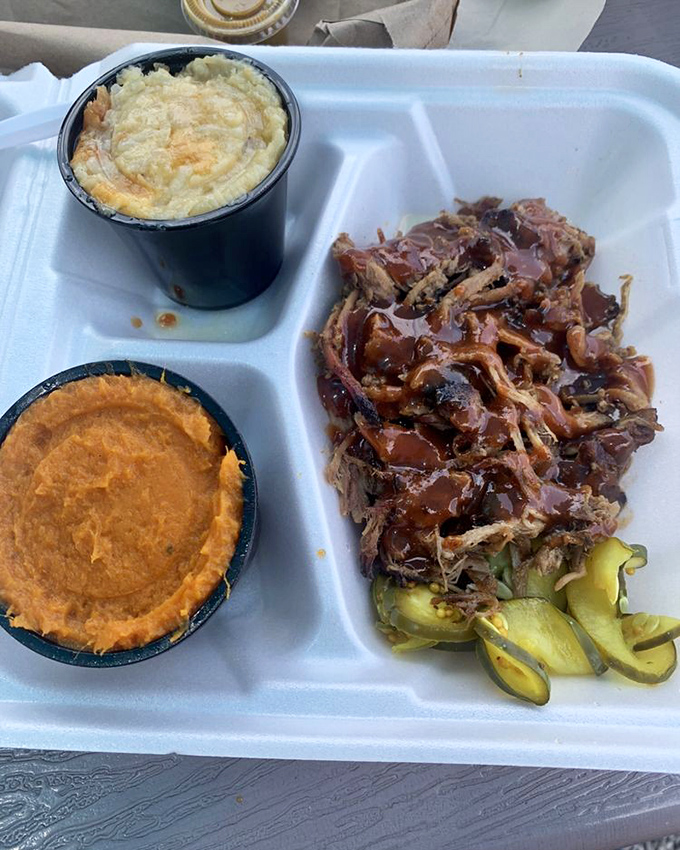 A plate that speaks the universal language of comfort: pulled pork with its caramelized edges alongside sides that refuse to be upstaged.