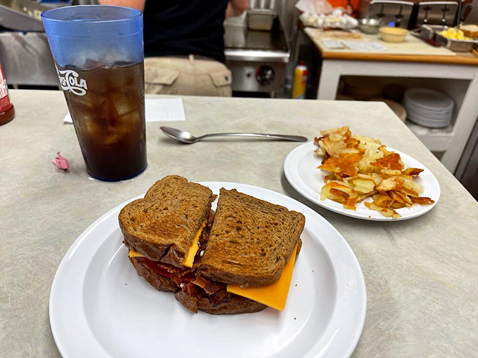 Not just a sandwich, but architecture you can eat. Layers of savory goodness between toasted bread, with home fries standing guard.
