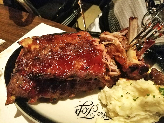 Baby back ribs so tender they practically surrender to your fork before you even touch them. The mashed potatoes look cloud-soft.
