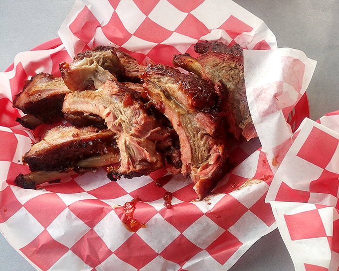 Baby back ribs with bark so perfect, they deserve their own trophy. That red-checkered paper is about to witness a beautiful disappearing act.