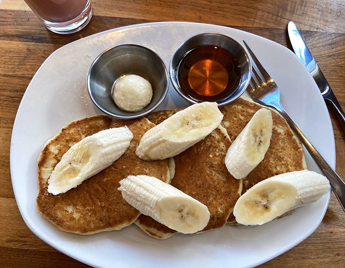 These pancakes are sporting banana slices like a fashionable hat at the Kentucky Derby&mdash;with maple syrup and butter standing by as willing accomplices to deliciousness.