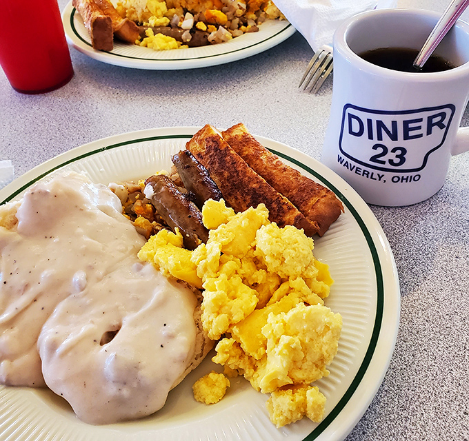Biscuits and gravy: the ultimate comfort food litmus test. Fluffy biscuits swimming in peppery sausage gravy alongside golden scrambled eggs and sausage links.