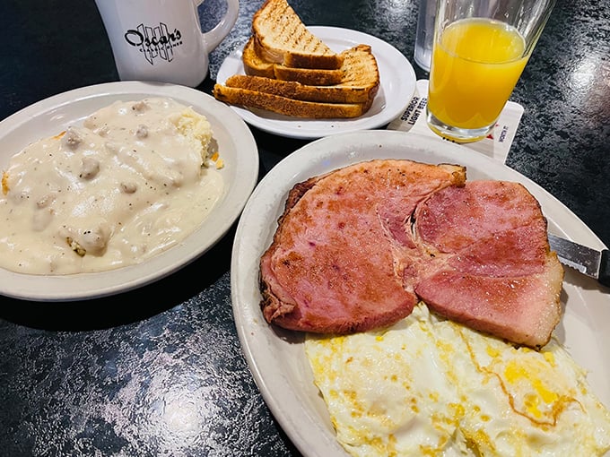 The breakfast trinity: ham steak, eggs, and a bowl of biscuits and gravy that could make a cardiologist weep &ndash; with both concern and envy.