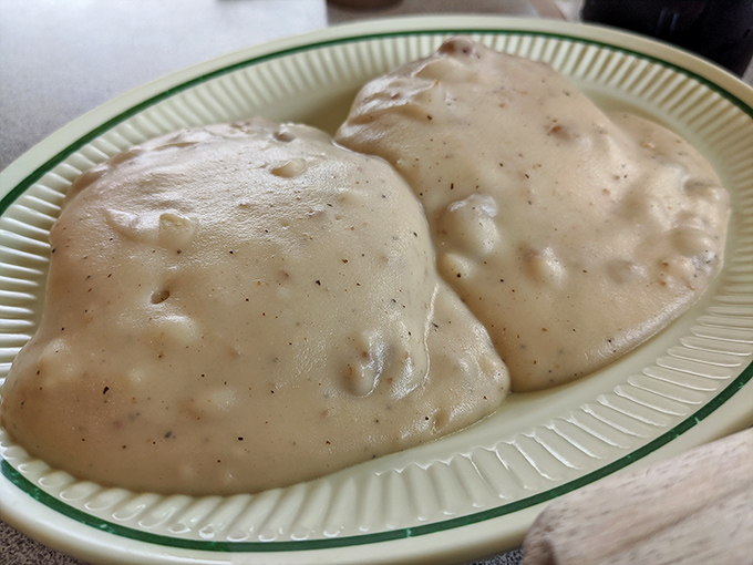 Biscuits and gravy: the ultimate comfort food that laughs in the face of diet culture. Two perfect clouds drowning happily in peppery gravy. 