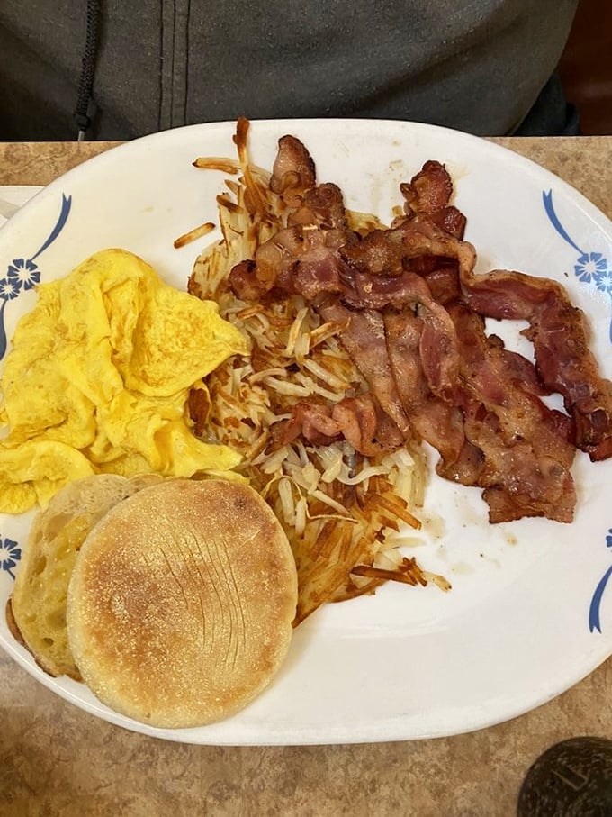 The breakfast trinity&mdash;crispy bacon, fluffy scrambled eggs, and hash browns&mdash;served with an English muffin that's actually been toasted properly.