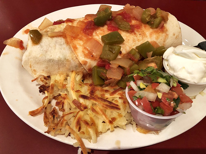 Breakfast burrito perfection: where eggs, cheese, and pico de gallo unite under one tortilla roof with crispy hash browns standing guard.