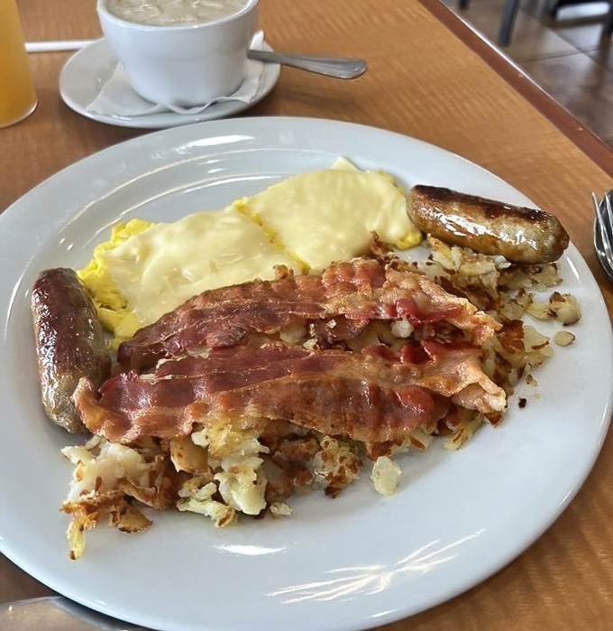 The breakfast holy trinity&mdash;eggs, bacon, and sausage&mdash;with home fries that clearly didn't come from a freezer bag. Morning victory on a plate.