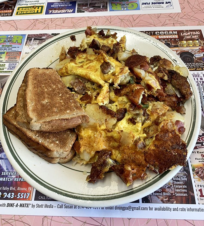When breakfast means business: eggs, meat, and potatoes sharing a plate in perfect harmony, like a well-rehearsed diner symphony.